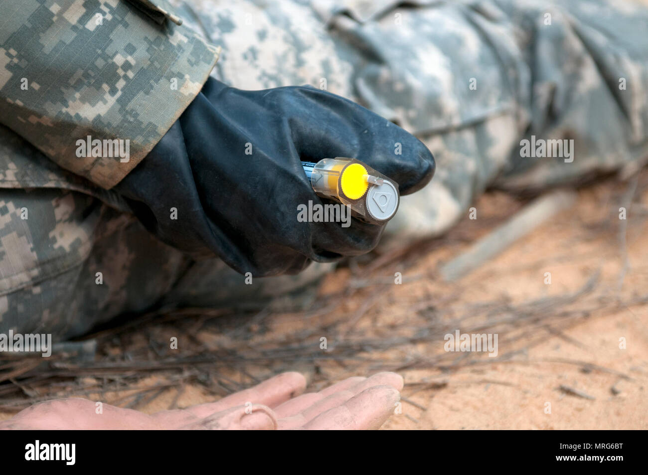 A warrior administers medicine to a mock downed soldier during the ...