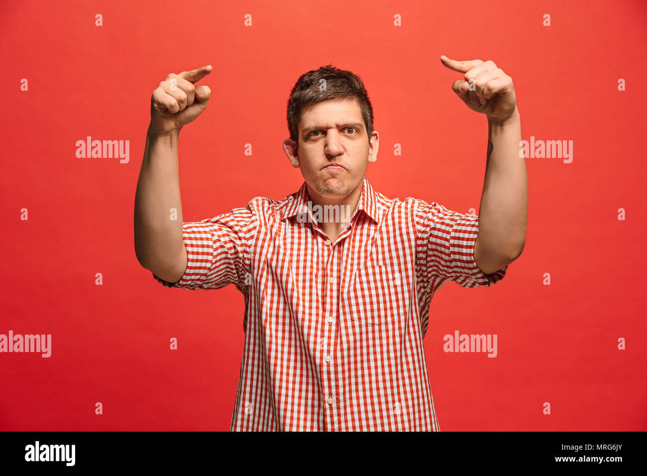 The young emotional angry man screaming on red studio background Stock ...