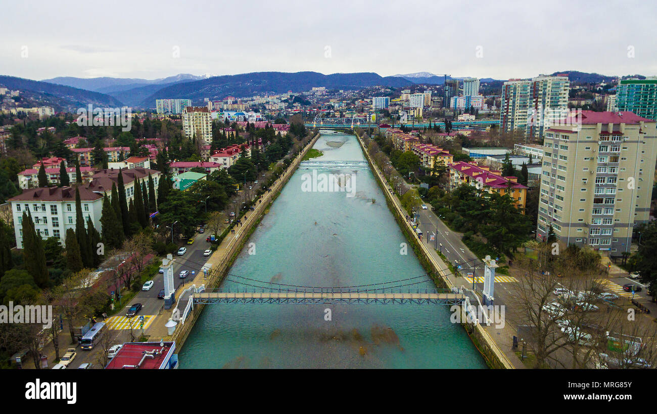 Drone view of Malyy Kubanskiy Bridge over Sochi River, buildings and ...