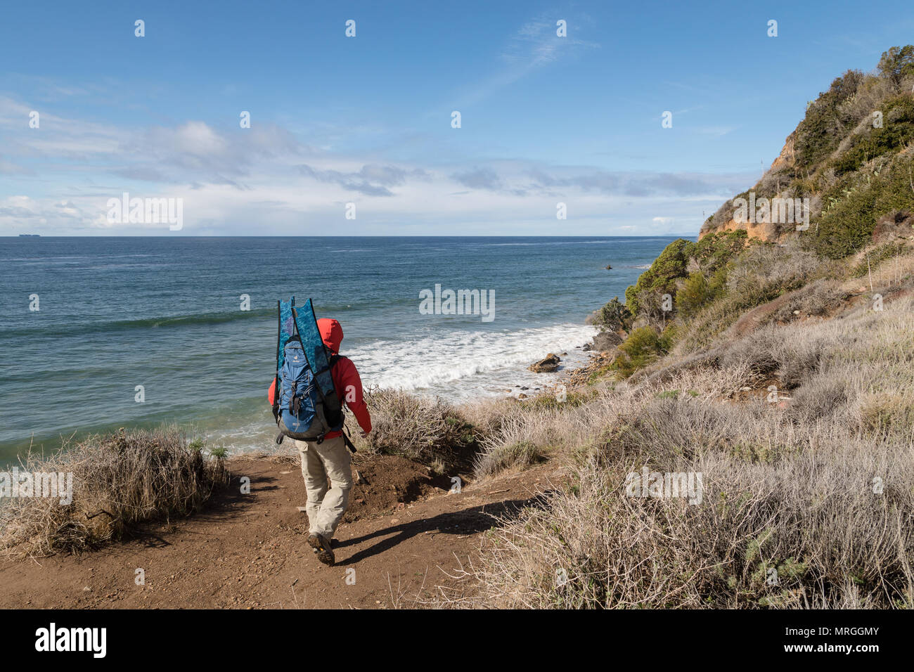A freediver wearing a backpack ready for adventure walks down toward ...