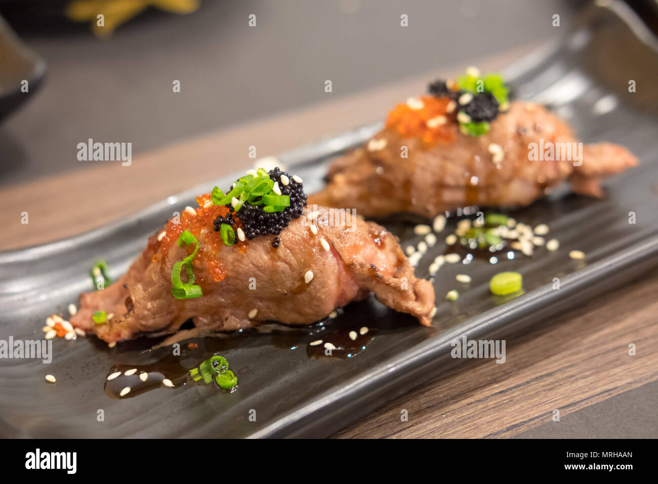Set of grilled Wagyu beef sushi with Flying fish roe or Tobiko on plate ...