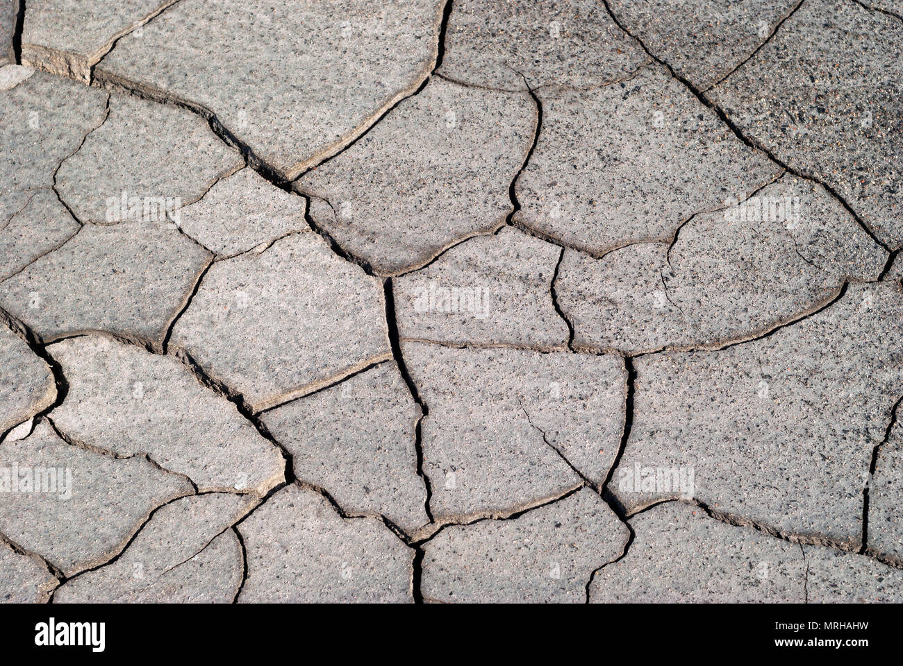 background - cracked dry sun-dried clay crust in a waterless desert ...