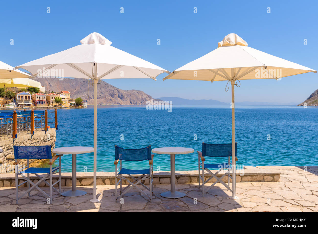 View of restaurant on sea coast on Symi island. Greece Stock Photo - Alamy
