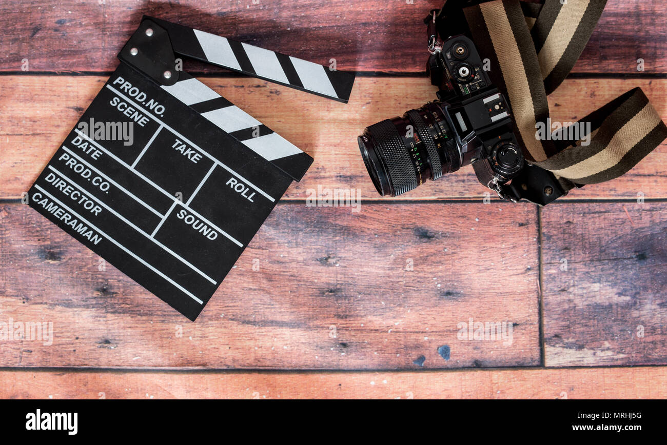 Movie clapper and old camera on a wooden background, movie shooting ...