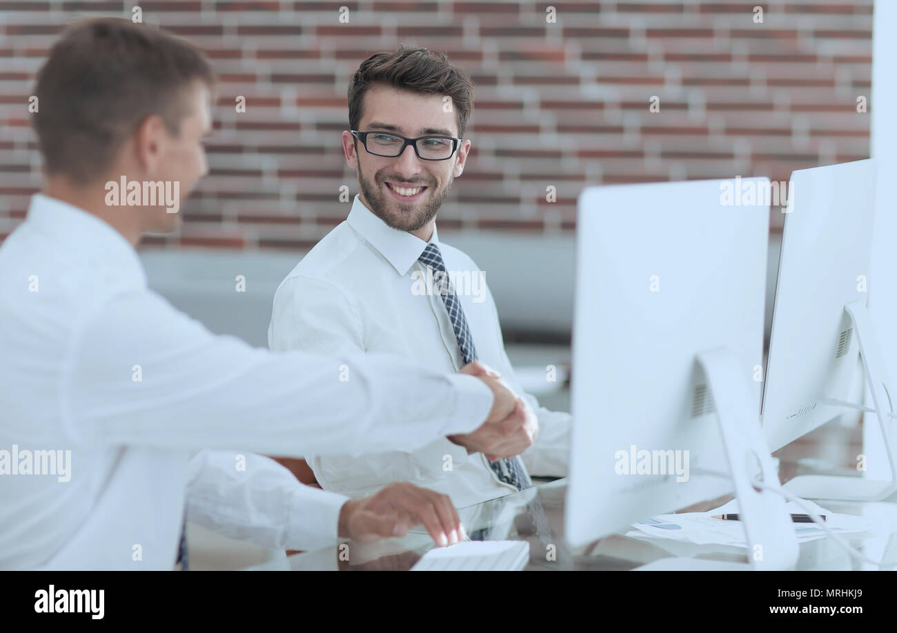 handshake of the employees at the Desk Stock Photo - Alamy