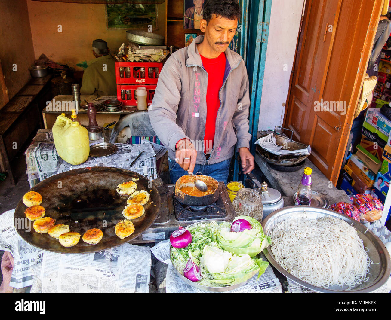Indian man cooking at a typical restaurant at the Market at Almora ...