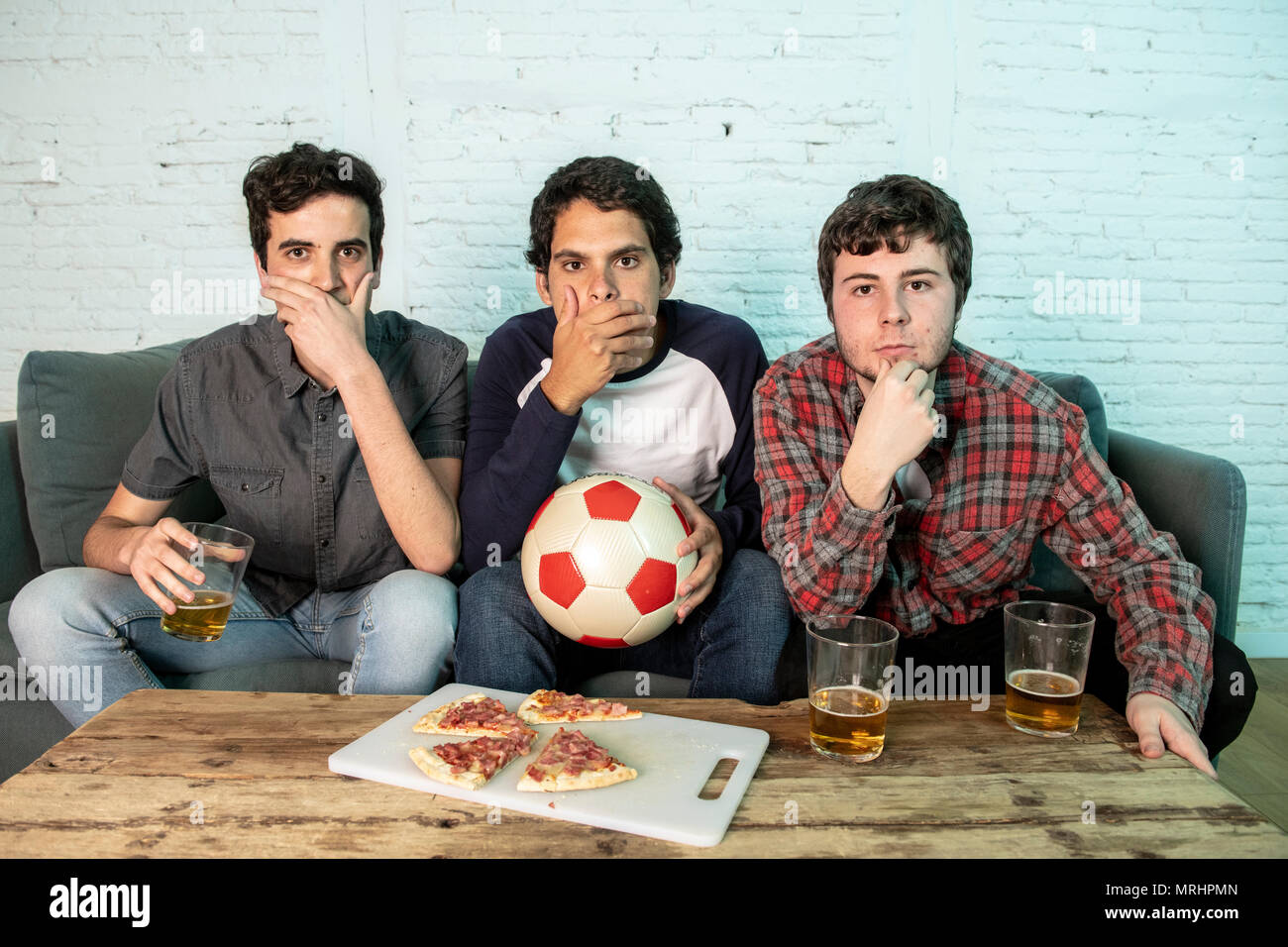 young caucasian football fans disappointed and angry watching a ...