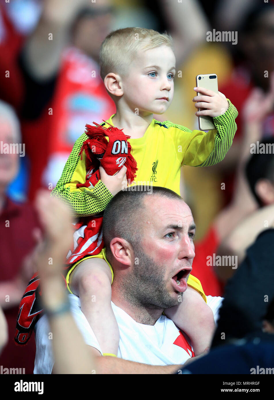A young Liverpool fan holds a phone in the stands prior to the UEFA ...