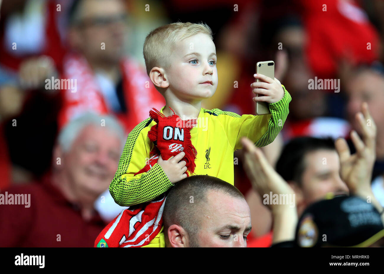 A young Liverpool fan holds a phone in the stands prior to the UEFA ...