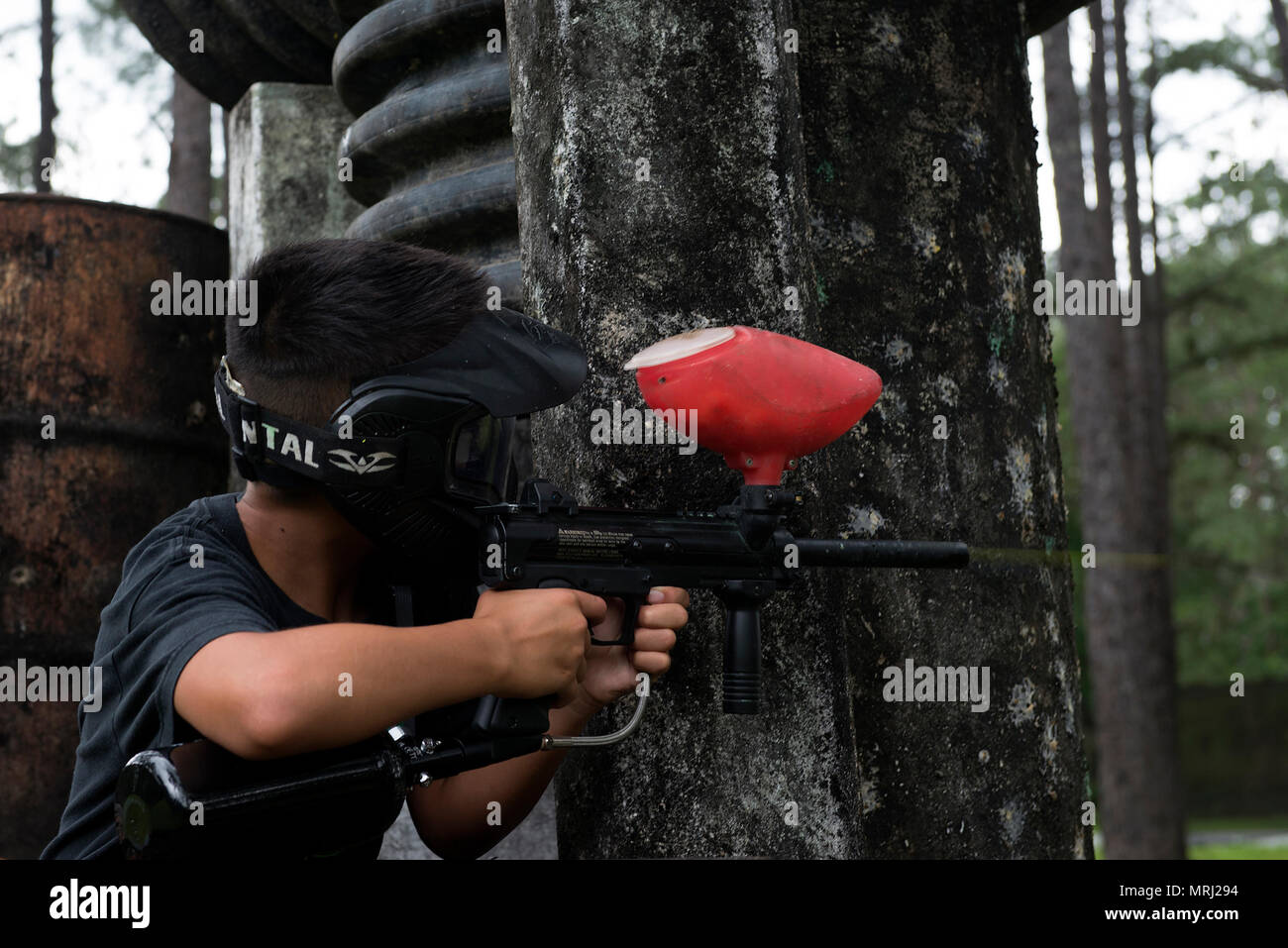 A competitor fires from behind cover at the Splatter Swamp Paintball ...