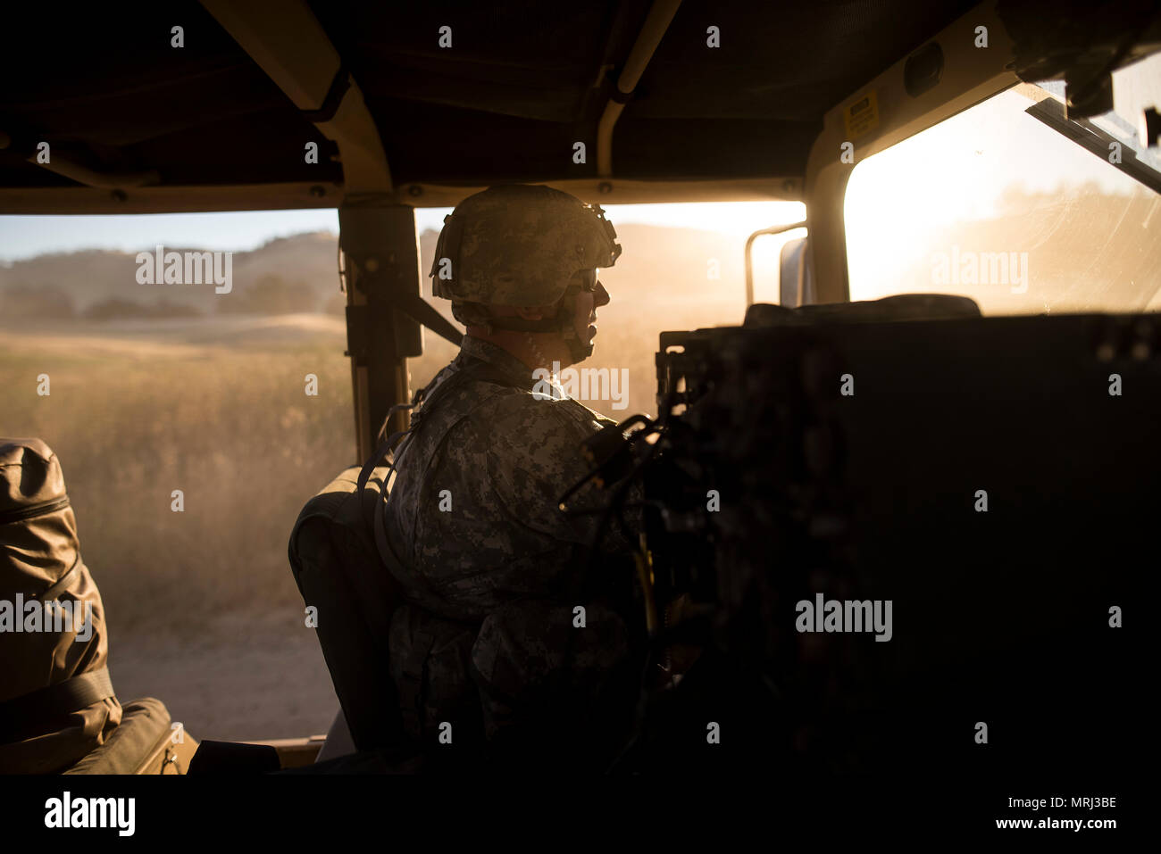 A U.S. Army "Observer, Coach, Trainer" rides behind a convoy run by the ...
