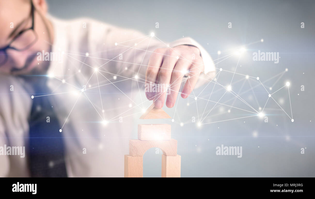 Young handsome businessman using wooden building blocks with ...