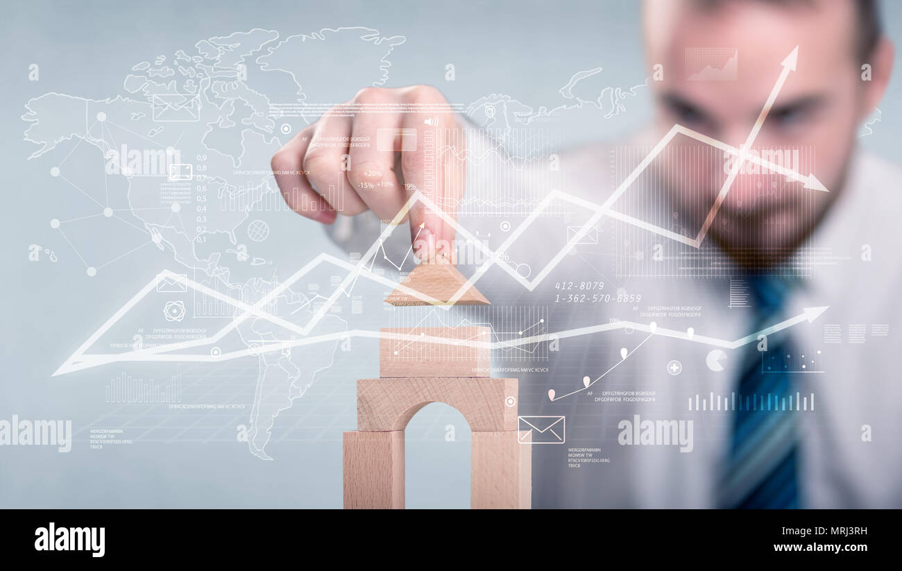 Young handsome businessman using wooden building blocks with data and ...