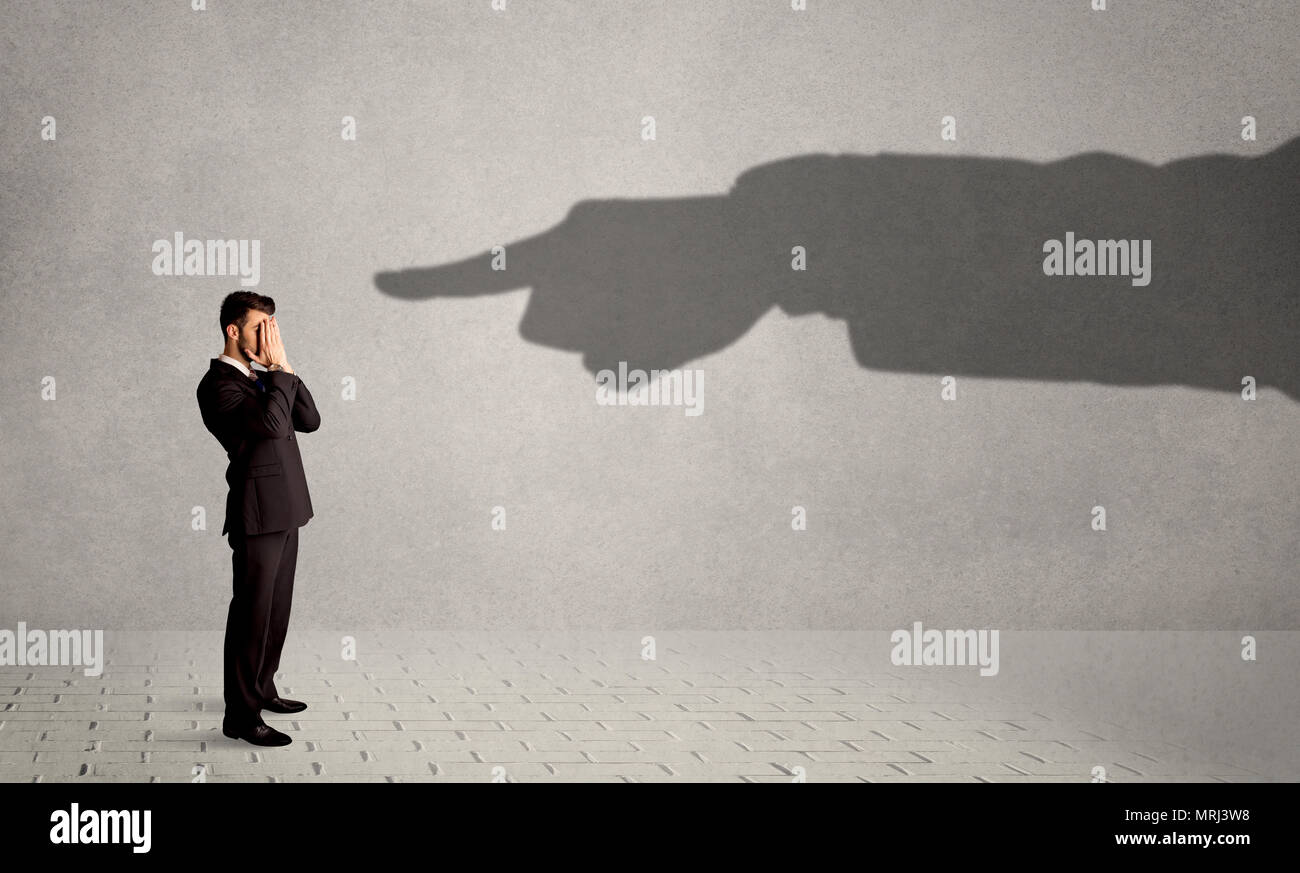 Business person looking at huge shadow hand pointing at him concept on ...
