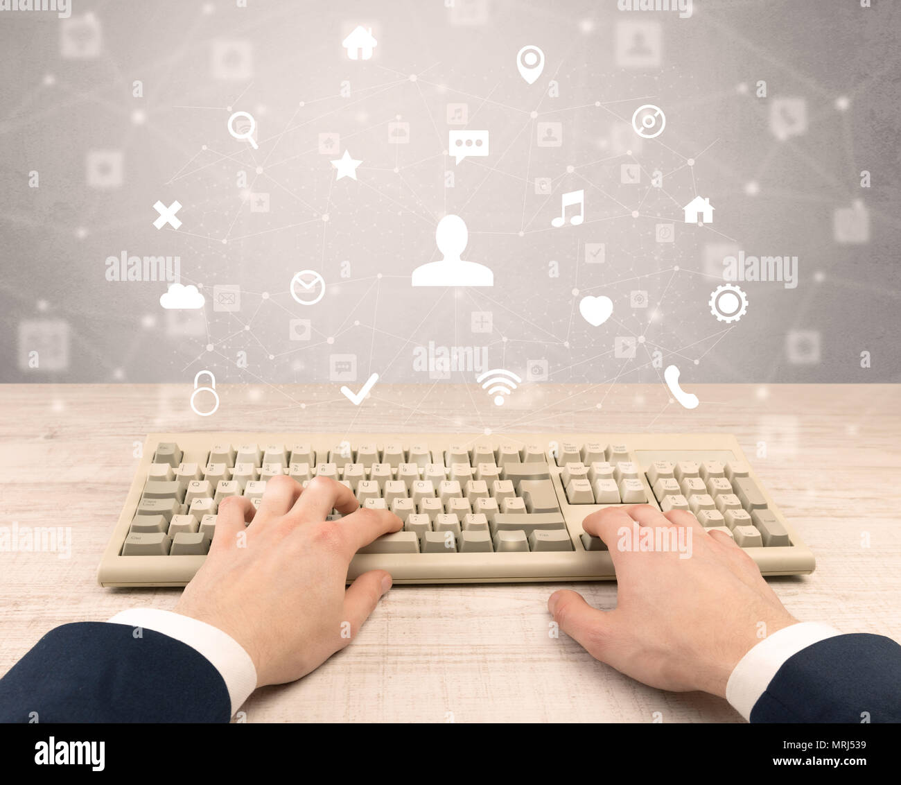 First person view of hand typing with social media concept icons around ...