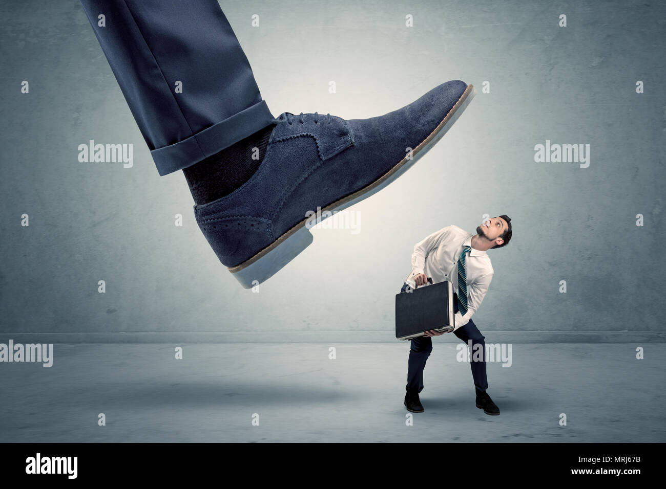 Demoralised employee symbolized by small man getting trampled Stock ...