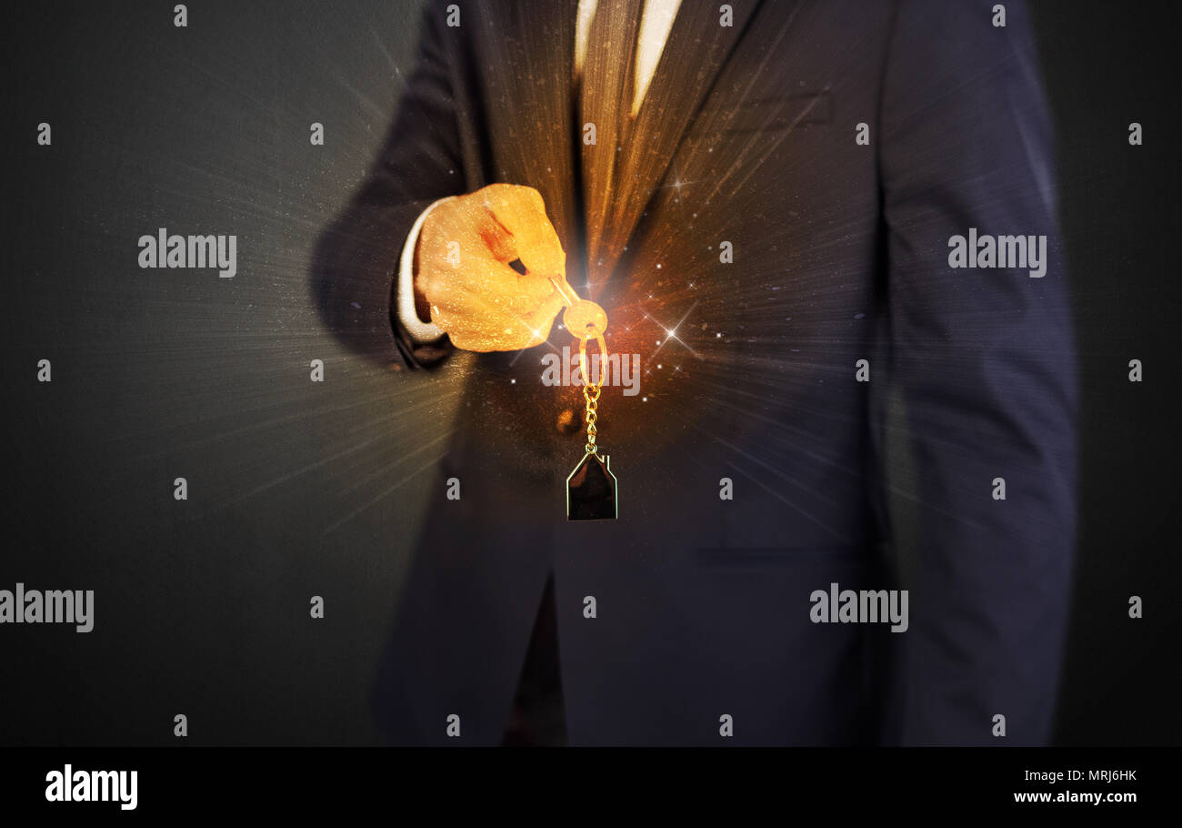 Formal man hand over shiny keys with dark background Stock Photo - Alamy