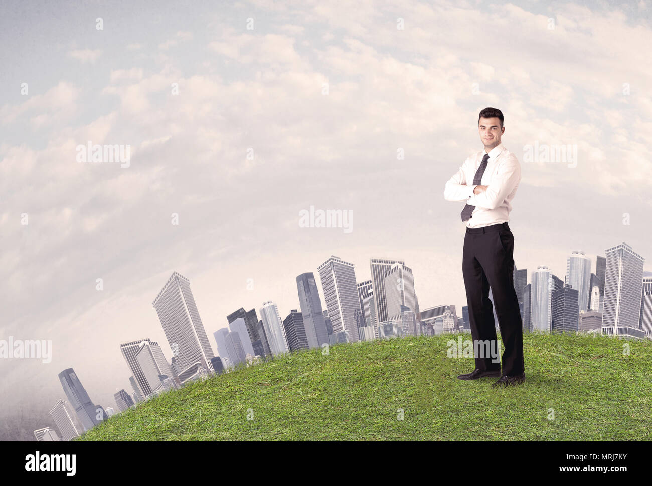 A successful male good looking business man standing in small green ...