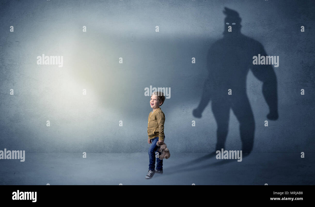 Cute kid in a room with plush on his hand and hero shadow on his ...