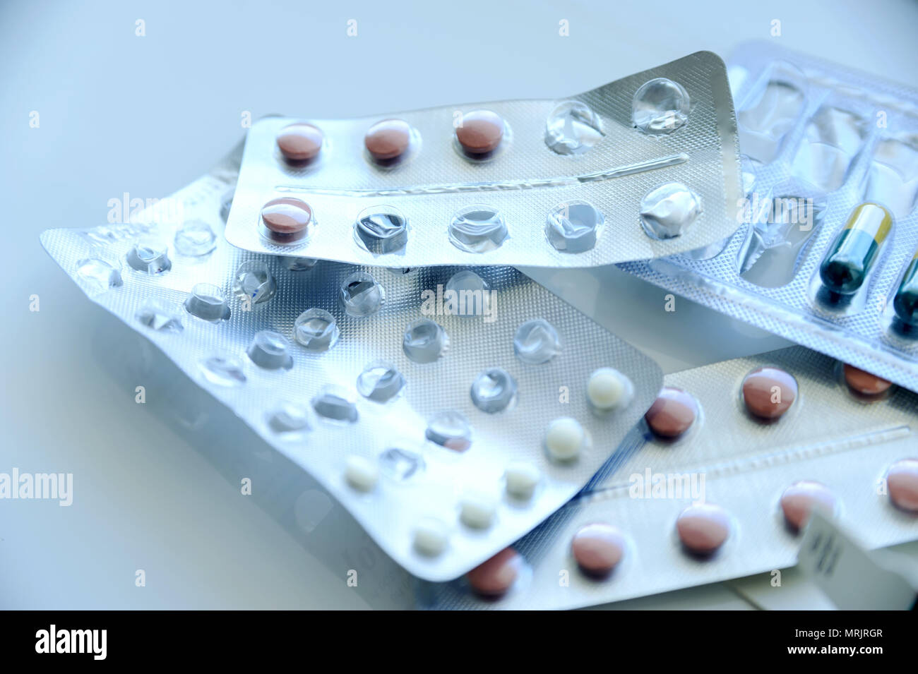 Different pills in blister packs on a white background Stock Photo - Alamy