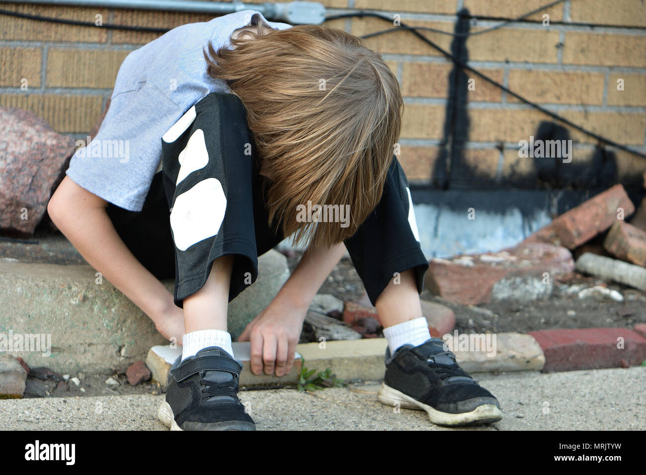 Boy sitting head down sad hi-res stock photography and images - Alamy