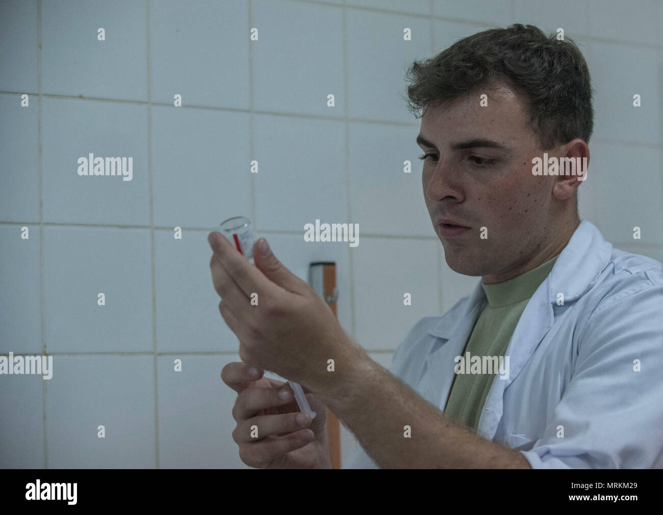U.S. Army Sgt. Thomas Chudzik, a practicing nurse specialist, prepares ...