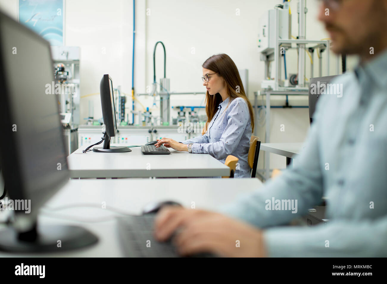 Side view of focused students using desktop pc in classroom at ...