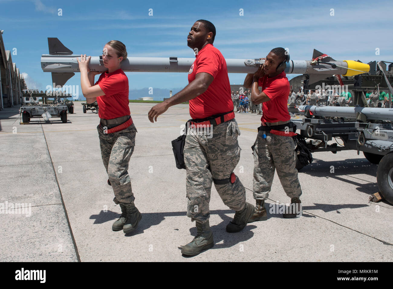 A weapons load team from the 67th Aircraft Maintenance Unit carries an ...