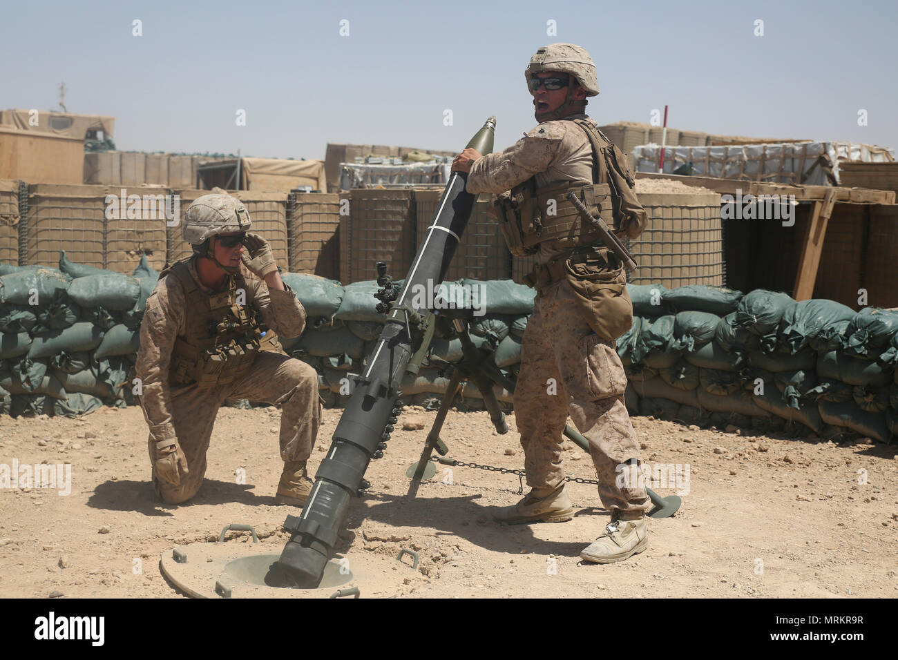 A Marine with Task Force Southwest inserts a round into a 120mm mortar ...
