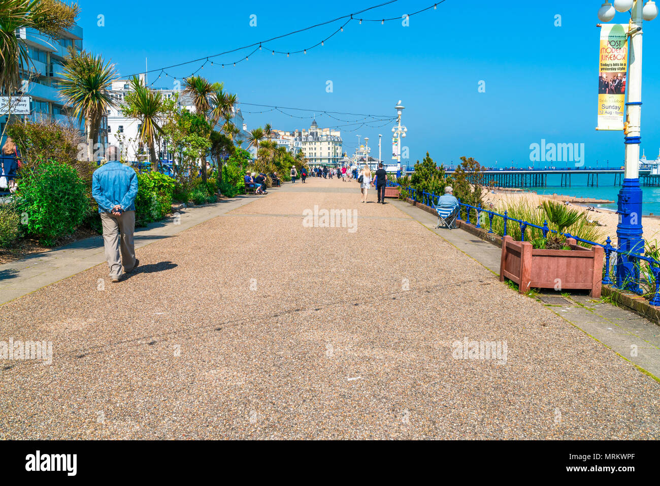 EASTBOURNE, SUSSEX, UK - MAY 20,2018:People stroll along promenade in ...