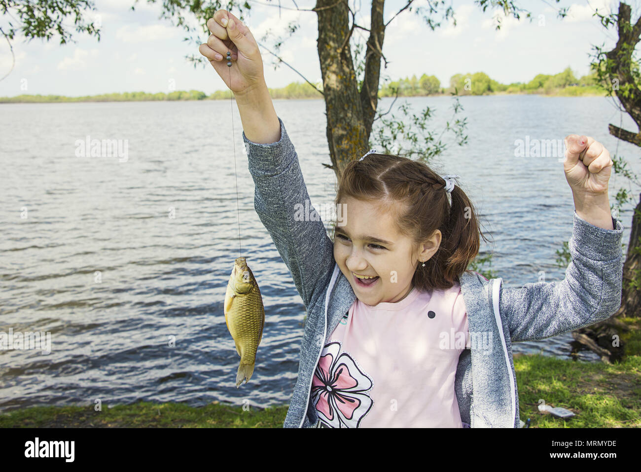 girl holding a fish caught in her hand ,rejoicing and smiling Stock ...