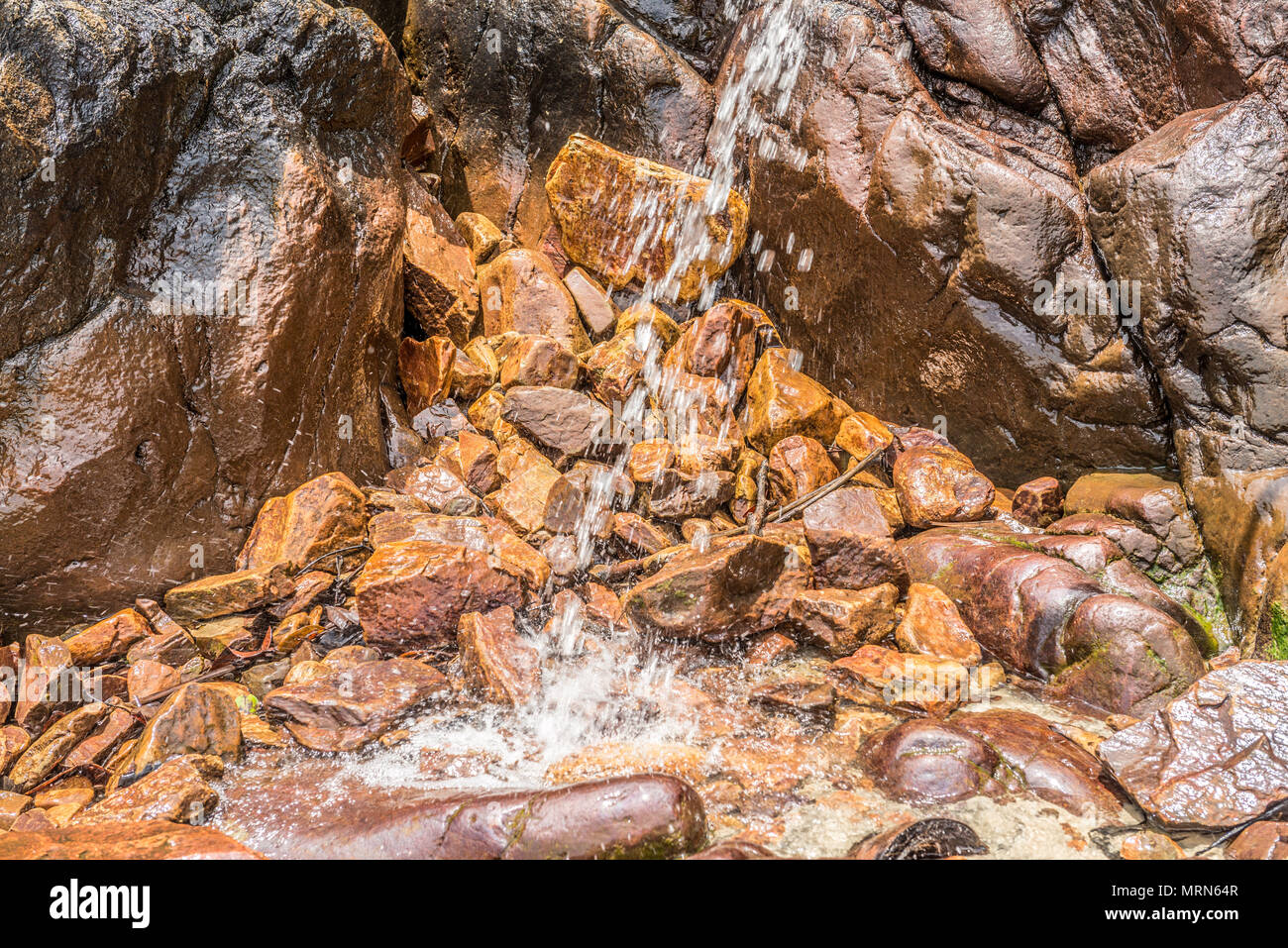 Small waterfall among rocks and stones in moss by the beach Stock Photo ...