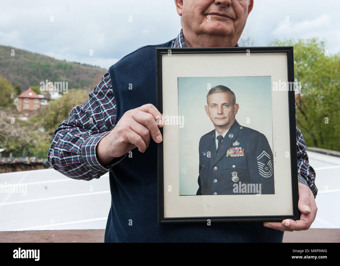 Retired Chief Master Sgt. Charles E. Milam poses with a photo of ...