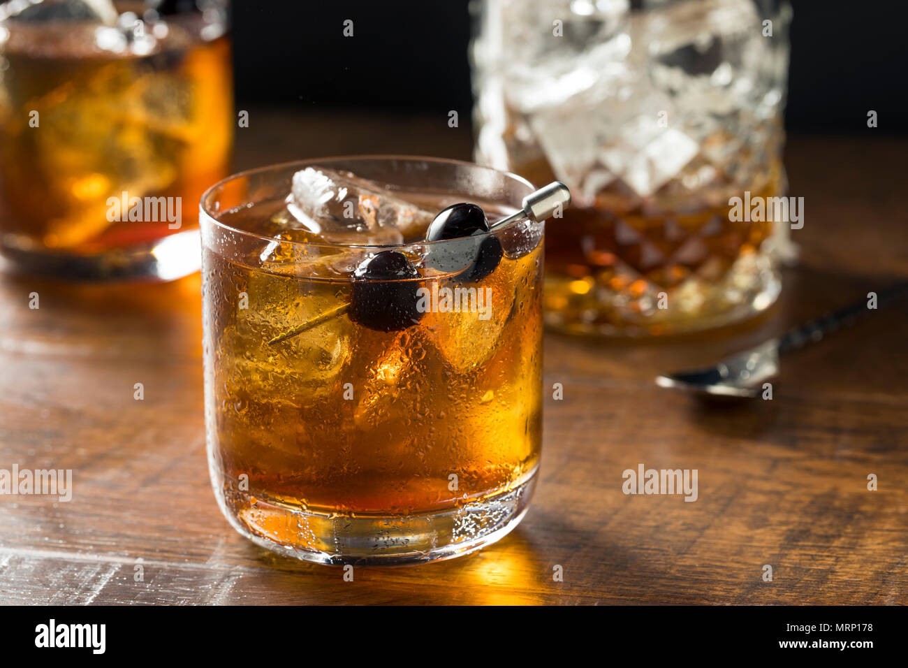 Boozy Manhattan Cocktail on the Rocks with a Cherry Garnish Stock Photo ...