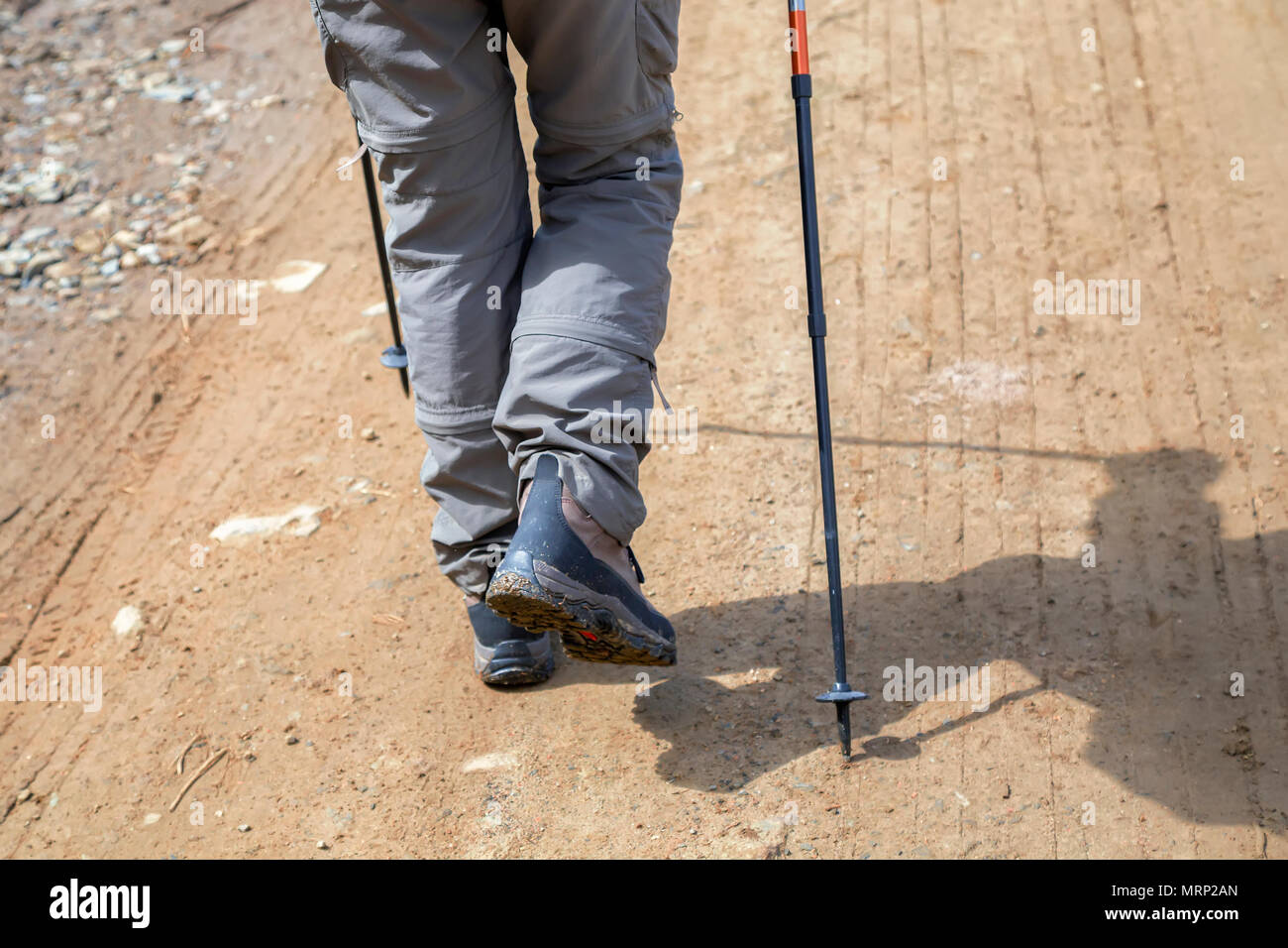 Traveling in mountains with hiking equipment, man legs in trekking ...
