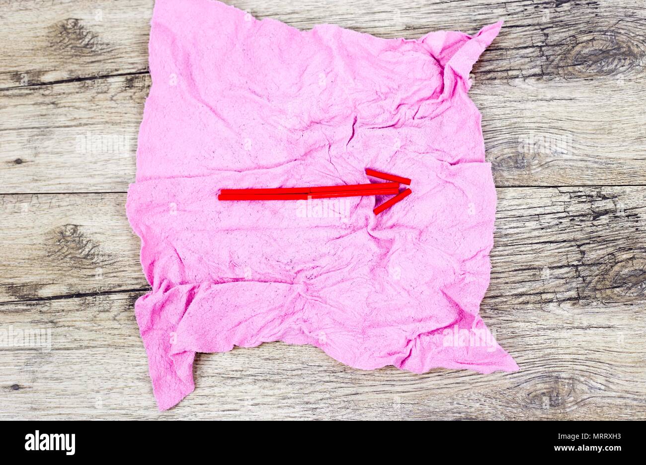 a red wooden arrow on a pink rag Stock Photo - Alamy