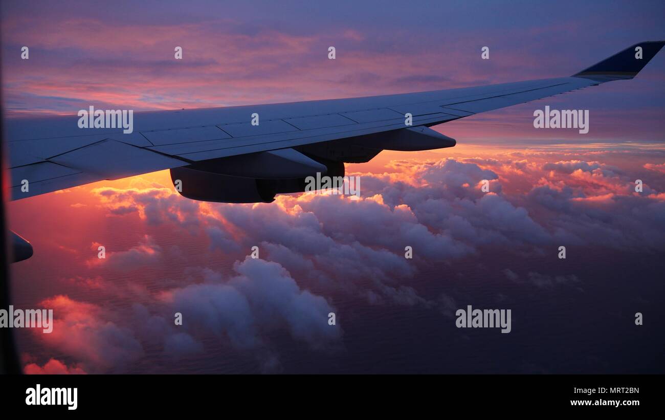 Sunrise from an airplane window above the clouds Stock Photo - Alamy