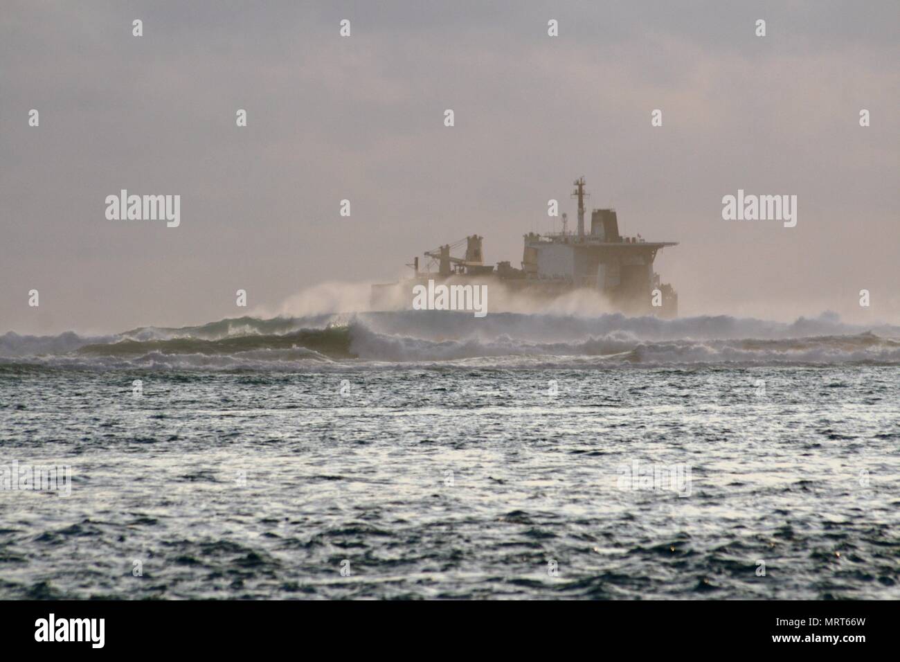 Huge angry waves rock a small vessel in the sea on a stormy day Stock ...