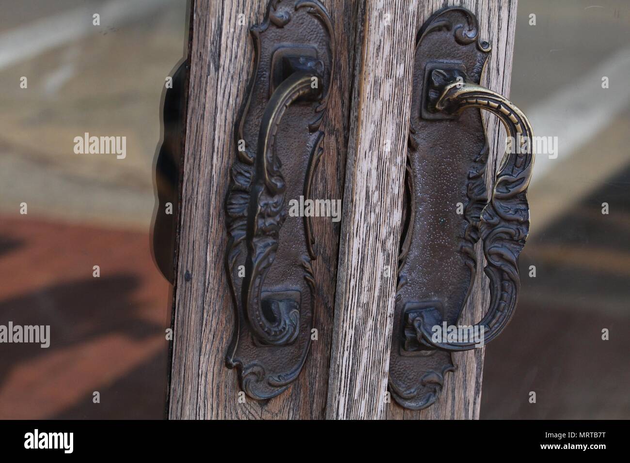 A pair of rusty metal handles on a wooden door Stock Photo - Alamy