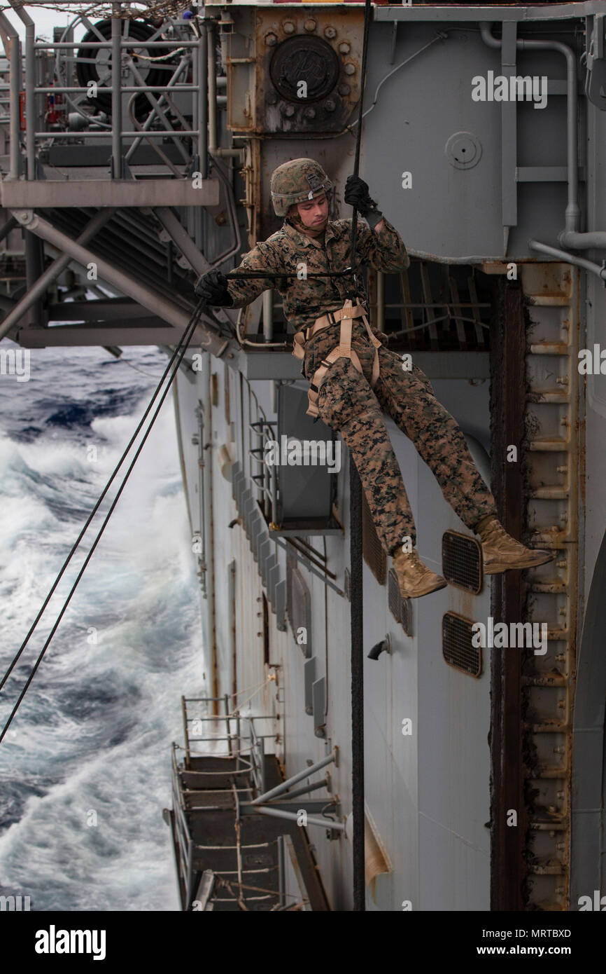 A Marine with the 31st Marine Expeditionary Unit rappels from the exit ramp of an MV-22B Osprey ...