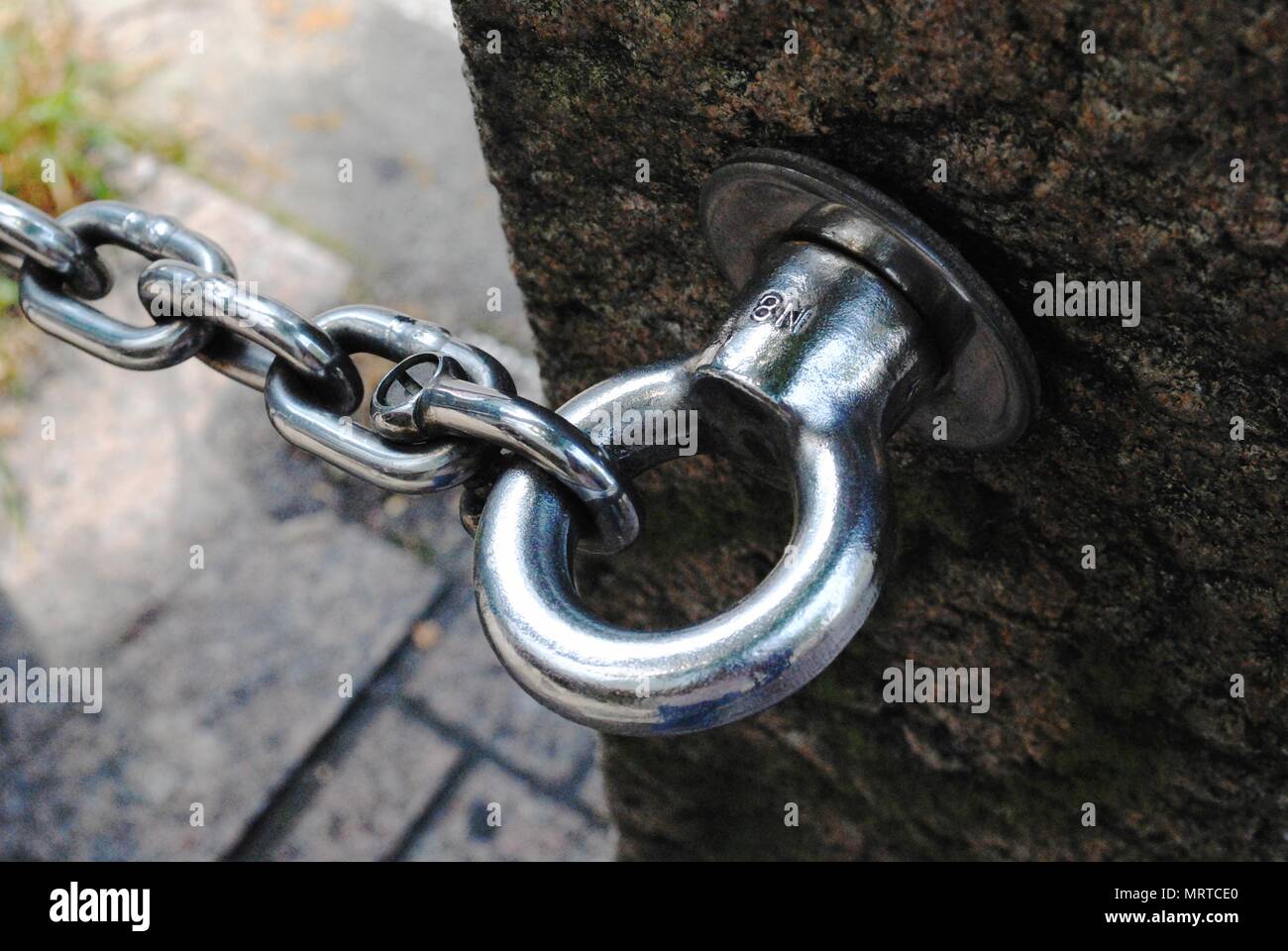 Close up of a strong silver chain fastened to a strong hook attached to ...