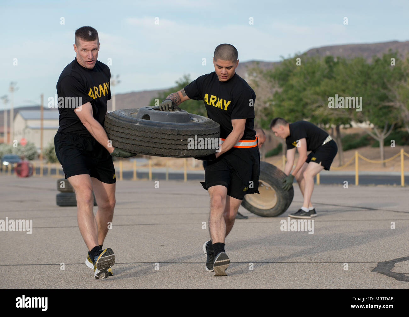 Sgt. Maj. of the Army Daniel Dailey, left, carries and stacks tires ...