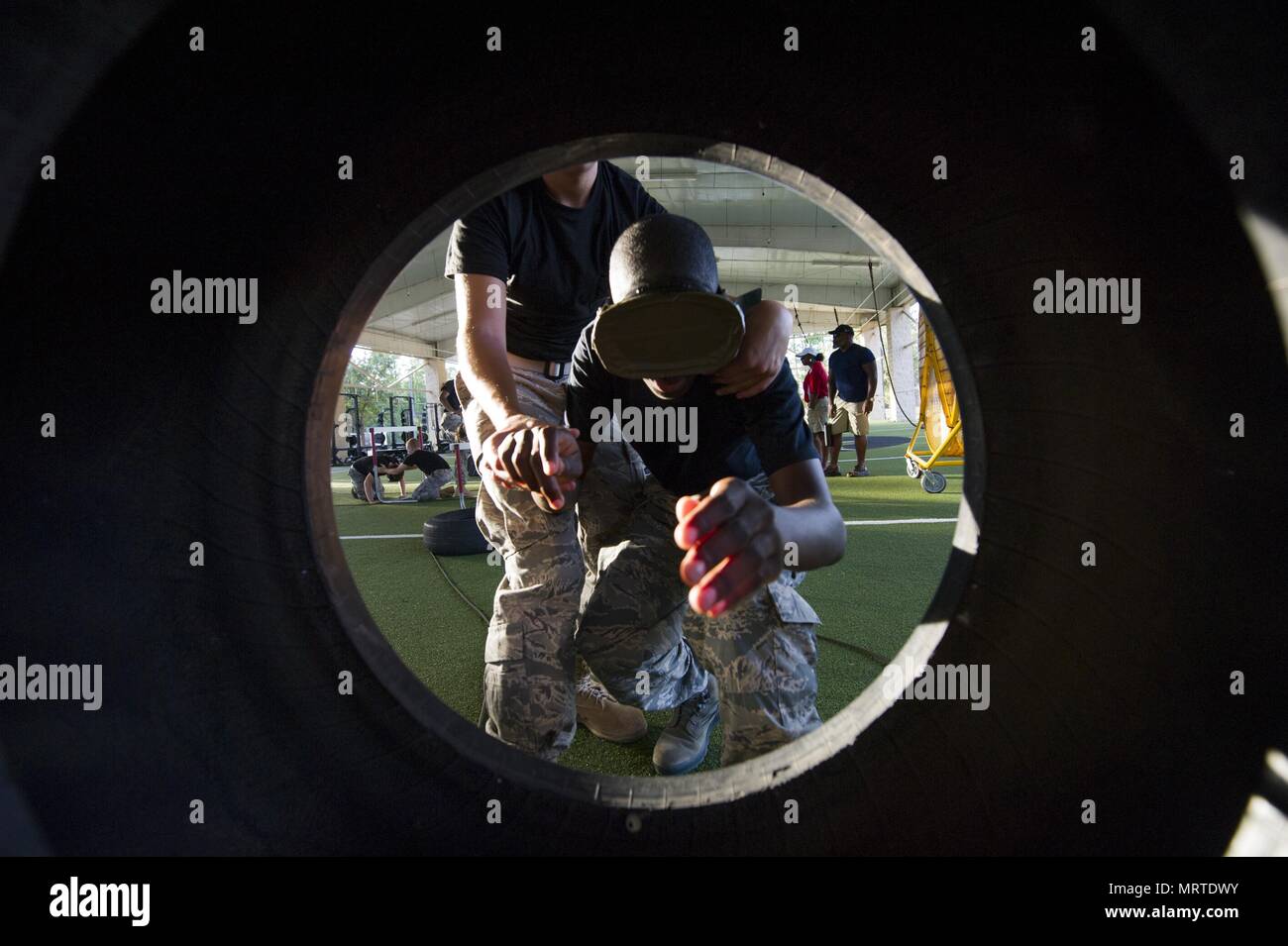 A blindfolded Junior ROTC cadet is guided through a tire at the end of ...