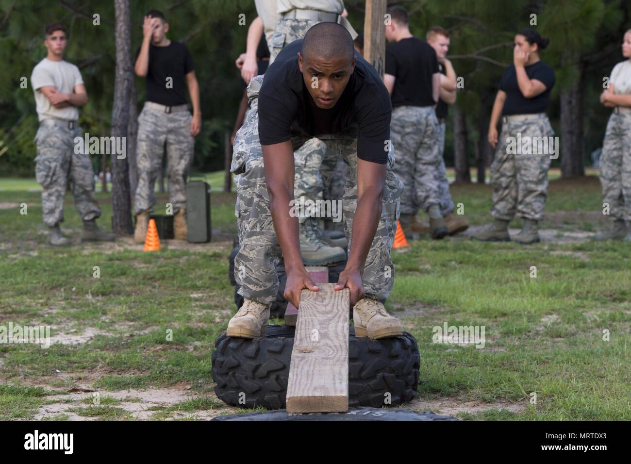 A Junior ROTC cadet lays a plank down to form a makeshift bridge ...