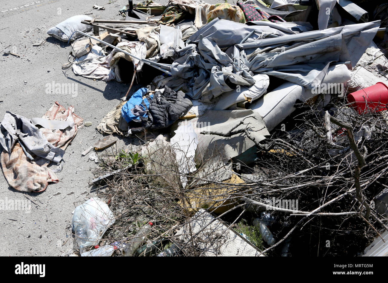 homeless shelter with broke mattresses and tatters rags and garbage ...