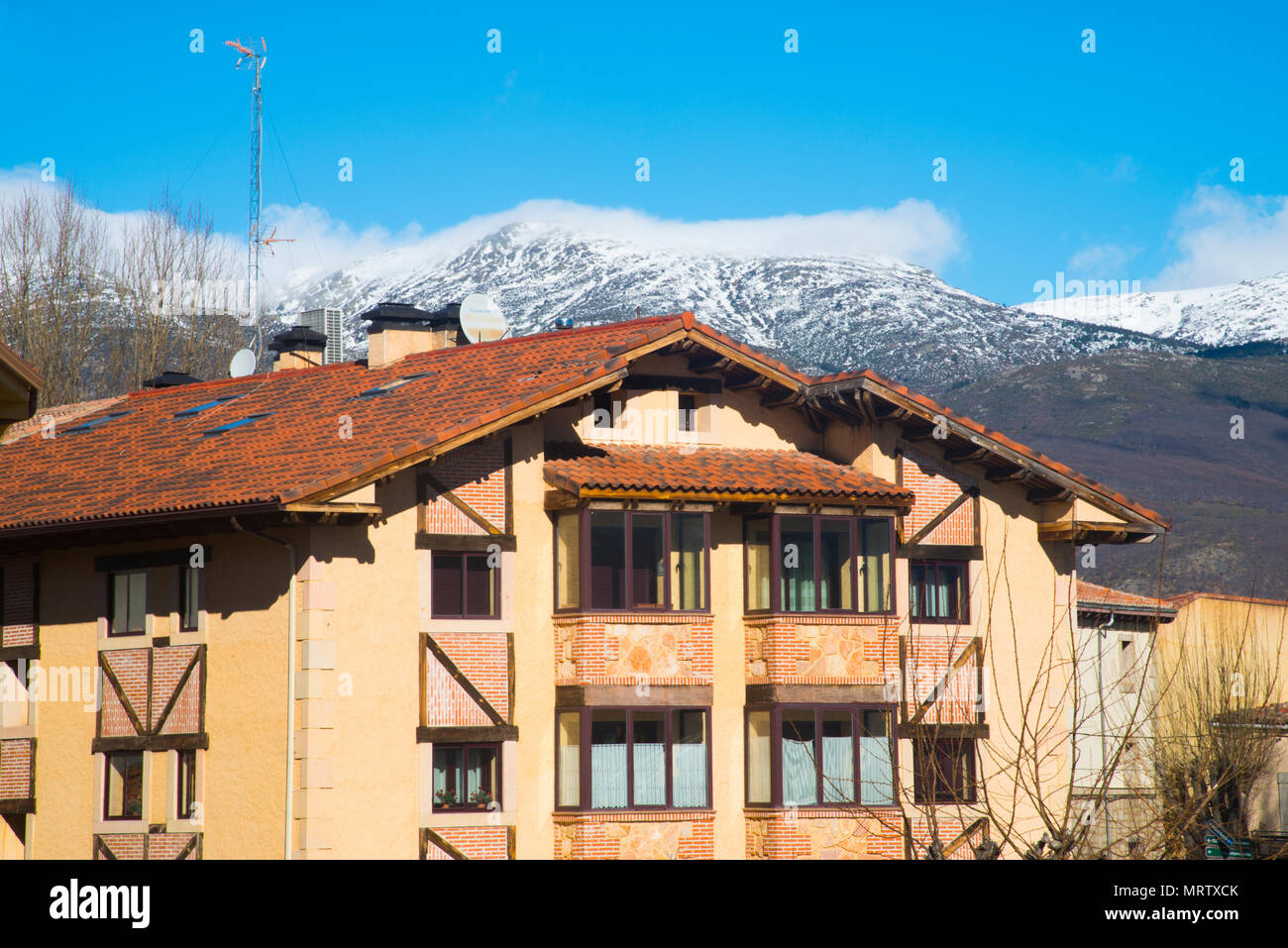 Facade of house and snow covered mountain. rascafria, Madrid province ...