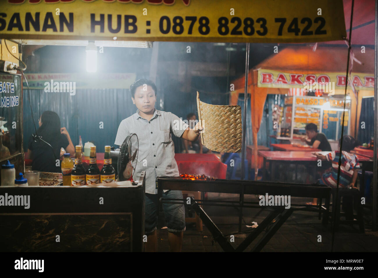 JAKARTA, INDONESIA - FEBRUARY 25, 2018: Hawker grilling satay on the ...