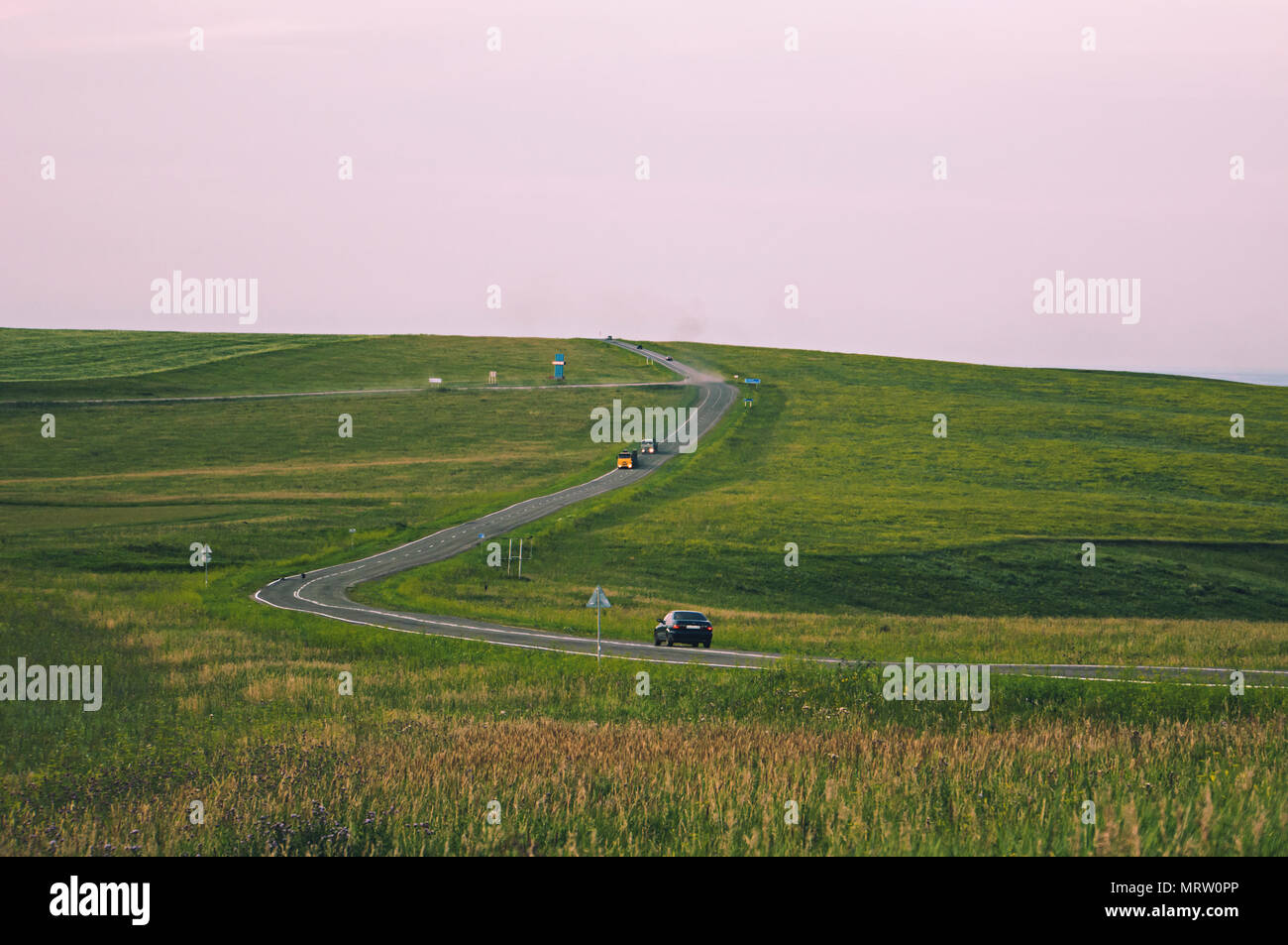 Cars driving on the road through the pass. The road stretches into the ...