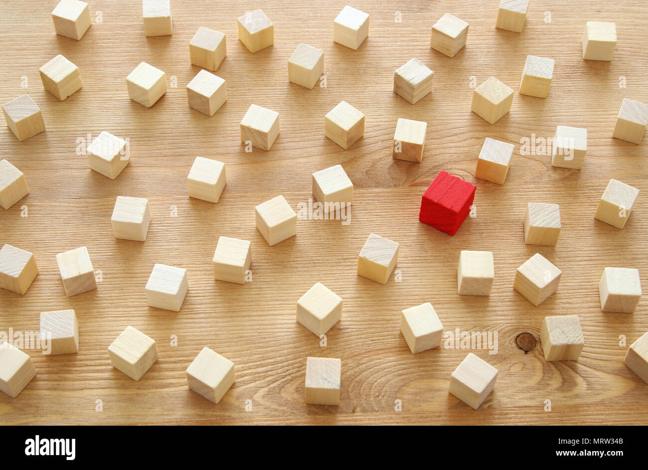 One different red cube block among wooden blocks. Individuality ...