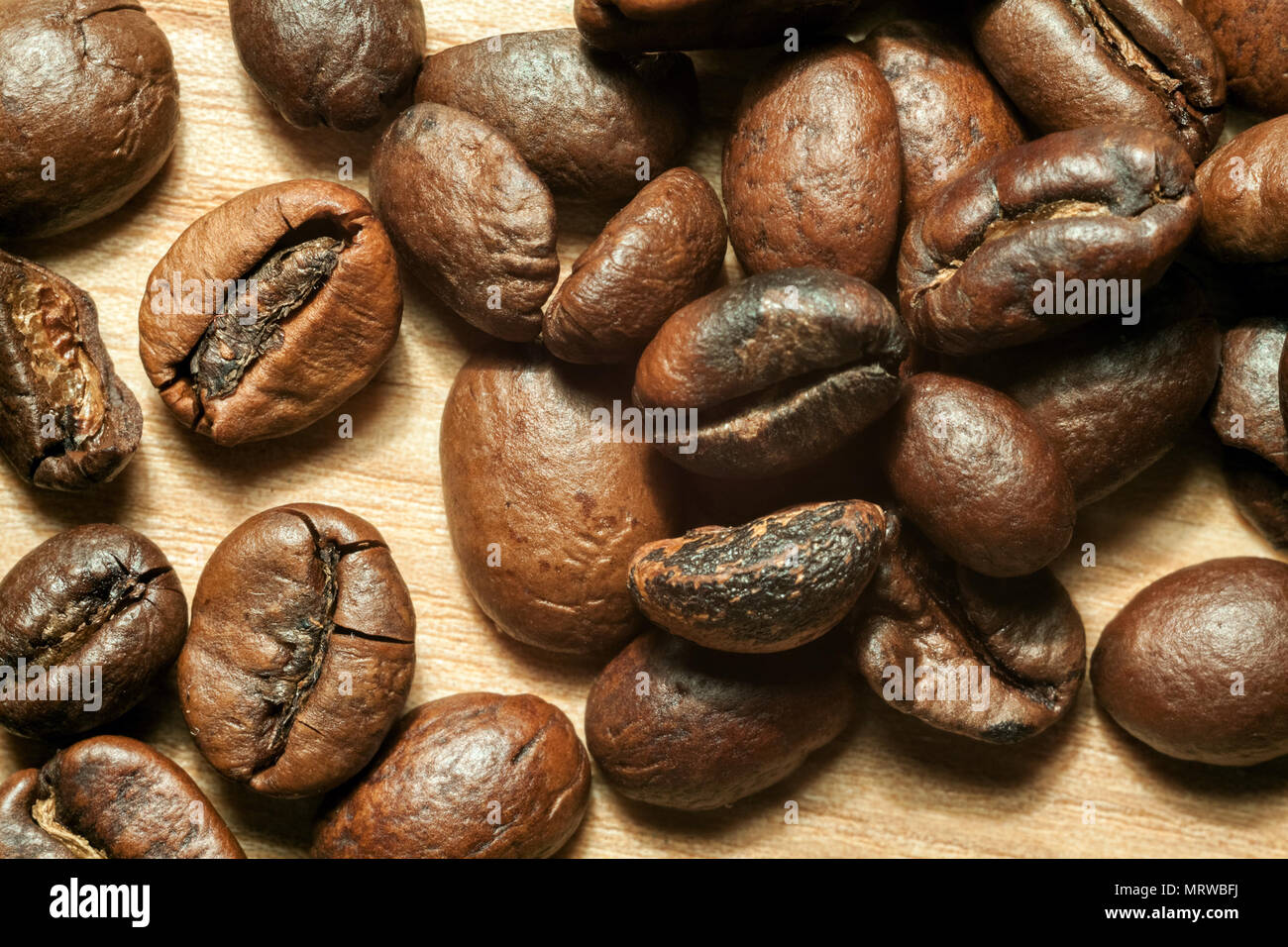 Coffee beans on beech tree background close-up Stock Photo - Alamy